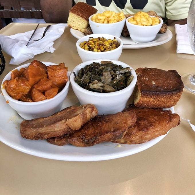 Pork chops and collard greens sharing a plate with mac and cheese and candied yams – a quartet that performs perfect Southern harmony.