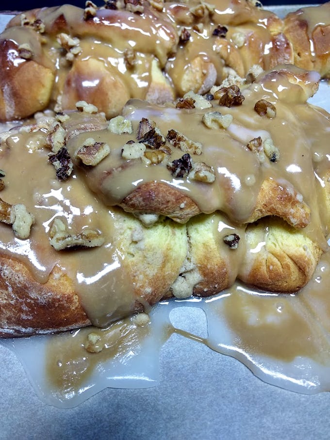 This isn't just a cinnamon roll—it's a caramel-drenched, pecan-studded monument to morning indulgence that demands to be photographed before it's devoured.