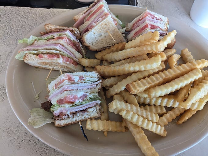 The club sandwich—architecture you can eat. Three stories of satisfaction held together with toothpicks and tradition, served with a side of nostalgia.