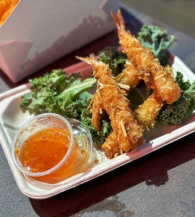 Golden-fried coconut shrimp that crunch like the soundtrack of vacation memories – dipping sauce included.