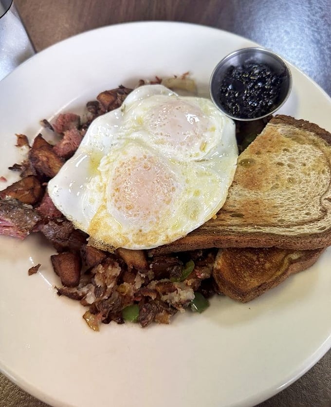 Breakfast nirvana: perfectly sunny-side-up eggs crowning a mountain of corned beef hash with toast standing by for yolk-sopping duty.