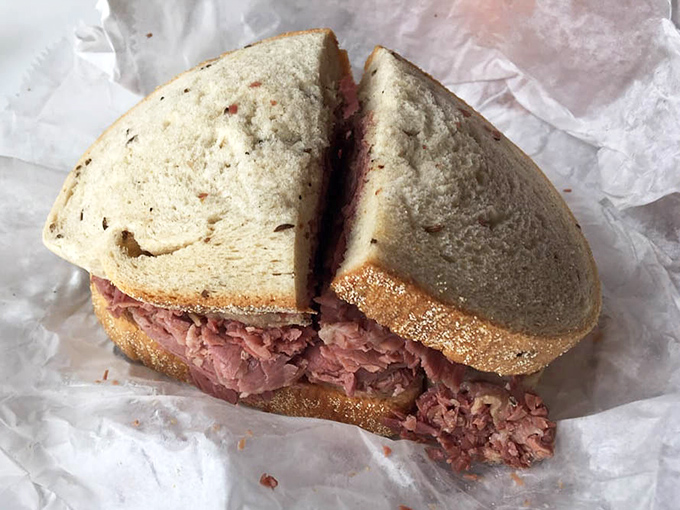 Behold the corned beef in all its pink, piled-high glory—a sandwich that demands both hands and possibly a nap afterward.