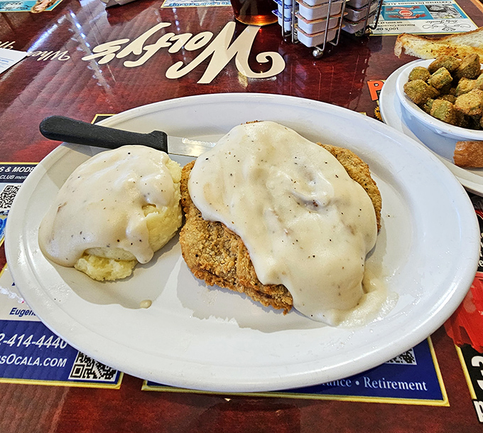 Country fried steak swimming in pepper-flecked gravy—the kind of breakfast that makes you want to cancel your other meals for the day.