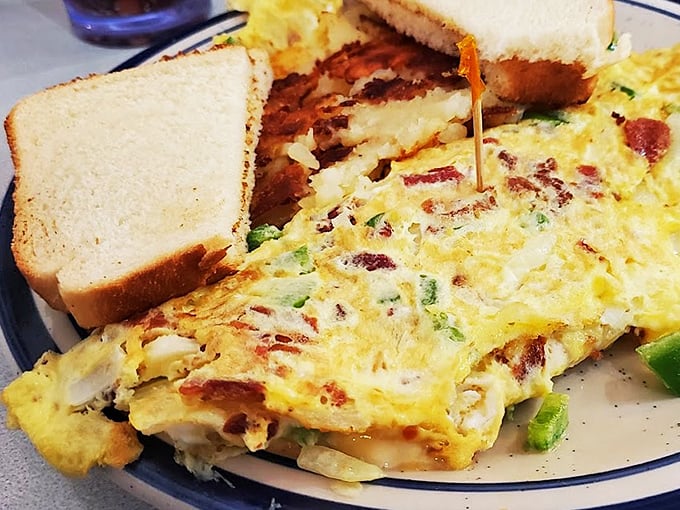 Breakfast perfection on a plate. This omelet doesn't just contain ingredients—it showcases them, with each bite delivering a perfect balance of flavors alongside golden toast.