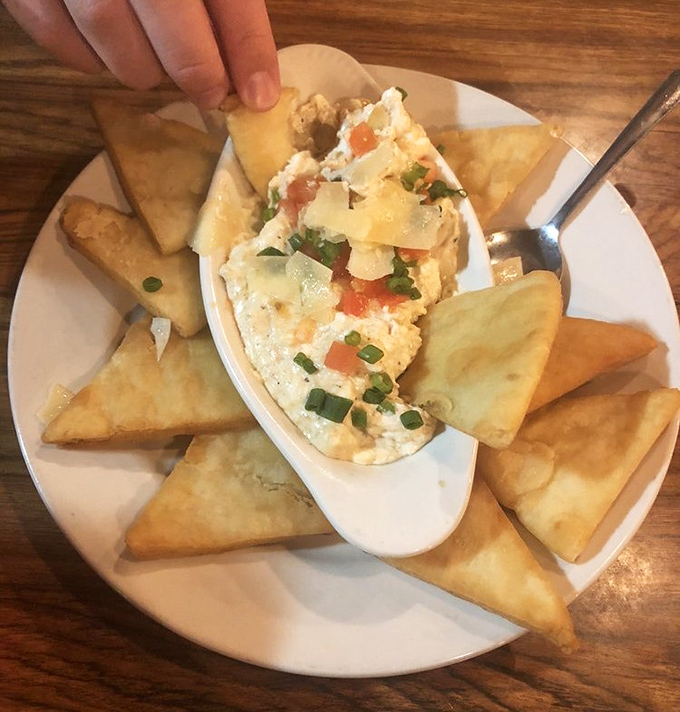 Dive right in! Golden pita triangles surround a creamy crab dip studded with colorful veggies—the perfect shareable start to your seafood adventure.