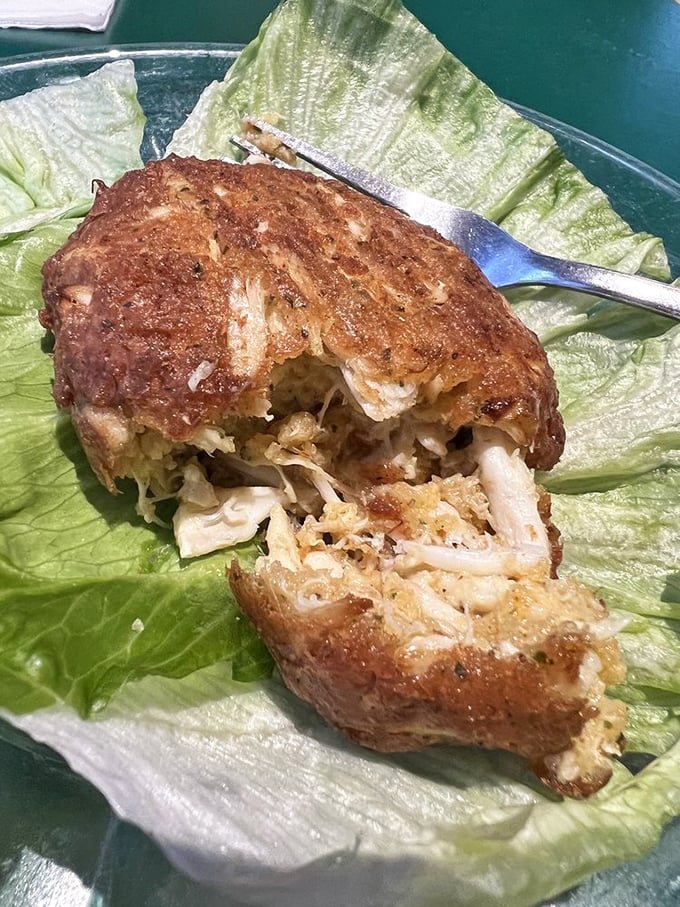 The legendary crab cake—almost entirely lump meat with minimal filler—sits like edible Baltimore history on a bed of lettuce, waiting to change your life.