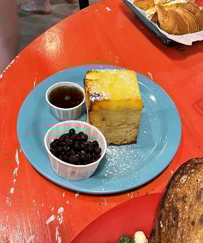 The Crème Brûlée French Toast arrives like breakfast royalty, with blueberries standing by as loyal courtiers to the caramelized throne.