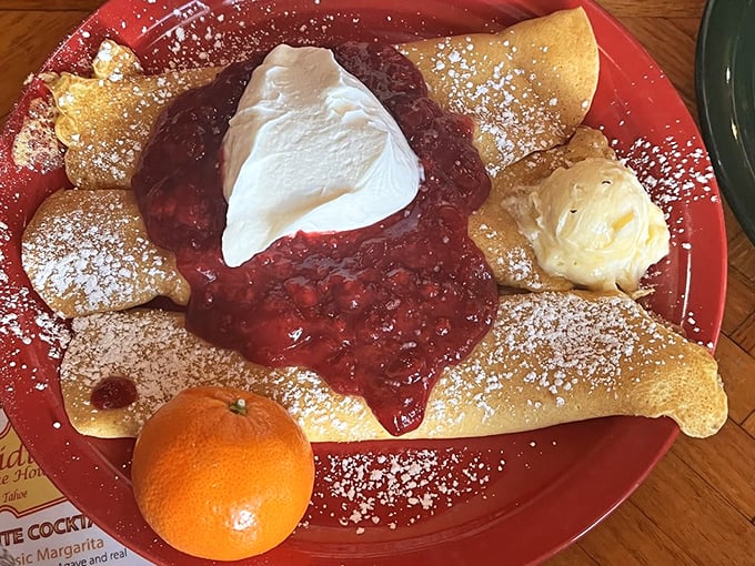 These crepes don't just serve fruit—they celebrate it. That mountain of strawberries and whipped cream is basically a breakfast carnival.