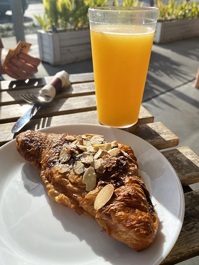 Golden-brown almond croissant paired with fresh orange juice—the breakfast combo that makes Monday feel like Saturday in Provence.