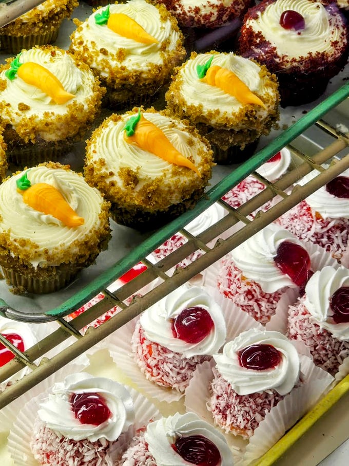 Carrot cake cupcakes topped with tiny orange carrots – the only vegetables you'll ever crave. Below, coconut-covered treats wait patiently for their moment of glory.