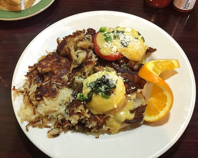 This Benedict isn't just eggs on an English muffin—it's a masterpiece of hollandaise architecture with perfectly crispy hash browns standing guard on the side.