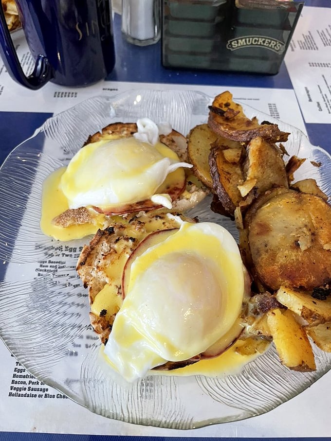 Eggs Benedict done right—where hollandaise sauce cascades like a yellow waterfall over perfectly poached eggs. Breakfast architecture at its finest.