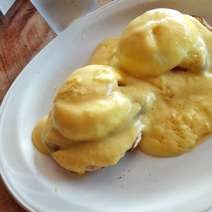 Eggs Benedict done right—English muffin, Canadian bacon, poached eggs, and hollandaise sauce forming a breakfast symphony that Mozart would envy.