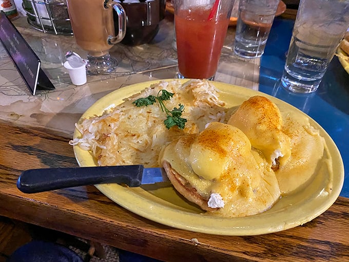 The Eggs Benedict arrives like sunshine on a plate – hollandaise cascading over English muffins with the kind of casual perfection that takes serious skill.