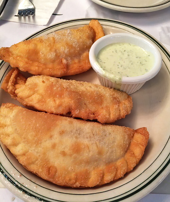 Golden empanadas that crunch like autumn leaves, hiding savory treasures within their flaky embrace.