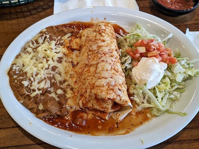 This enchilada isn't just covered in sauce – it's swimming in a pool of flavor with cheese playing lifeguard. Diet plans, beware.