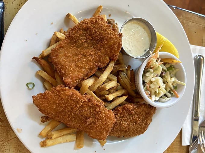 Crispy on the outside, flaky within – this fish and chips platter isn't just food, it's edible sunshine accompanied by creamy coleslaw and tangy tartar sauce.