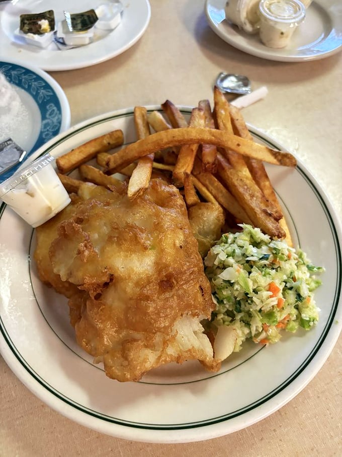 Behold the holy trinity of fish, chips, and coleslaw—a plate so perfectly balanced it could bring peace to warring nations.