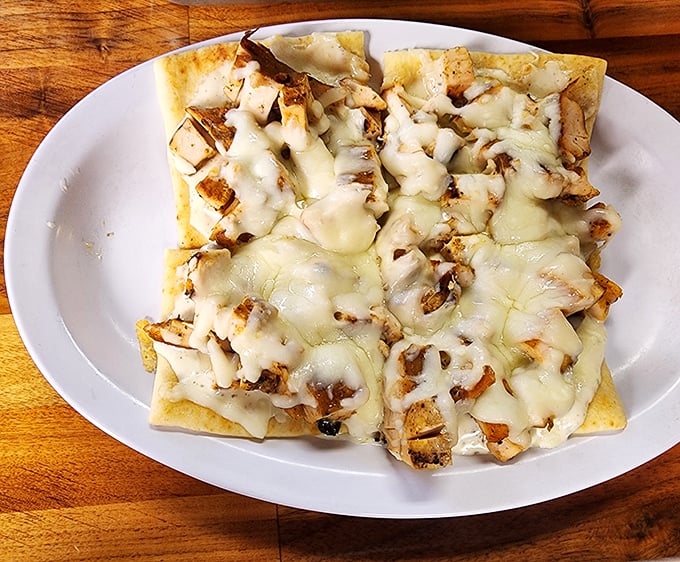 This flatbread isn't trying to be fancy – it's just honest-to-goodness BBQ chicken melted under a blanket of cheese that stretches for days.