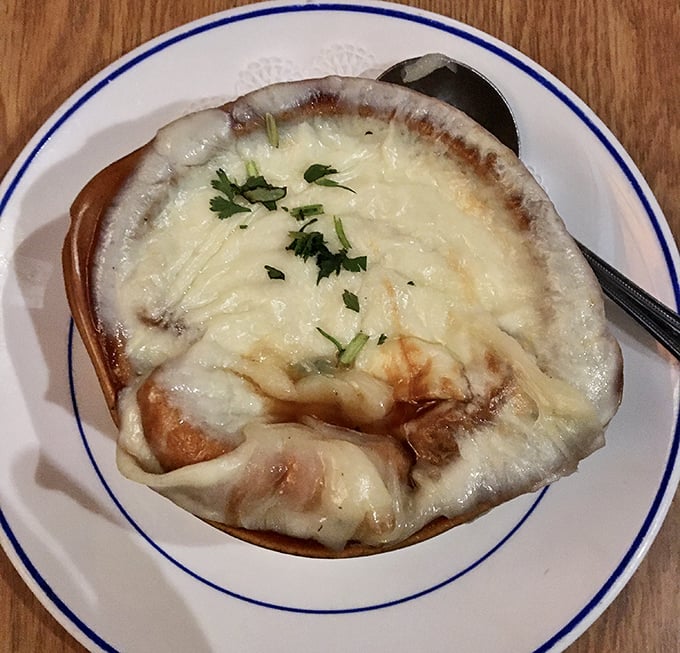 This isn't just French onion soup—it's a cheese pull championship waiting to happen. Dive beneath that melty canopy to find rich, savory broth.