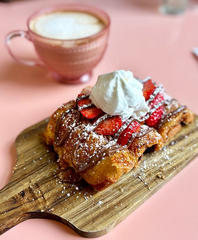 This isn't French toast—it's a dessert masquerading as breakfast, with strawberries and cream that would make Marie Antoinette say "forget the cake."