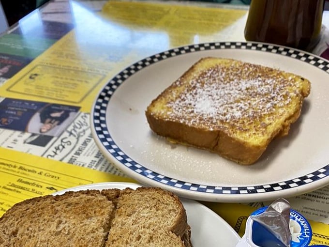 French toast dusted with powdered sugar sits regally on a checkered plate – simple perfection that doesn't need to show off.