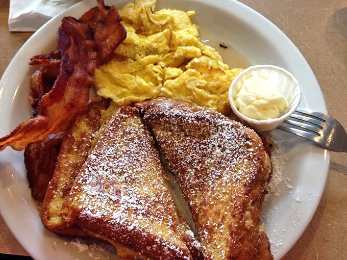French toast that puts ordinary bread to shame, dusted with powdered sugar like a winter morning and flanked by perfectly crisp bacon.