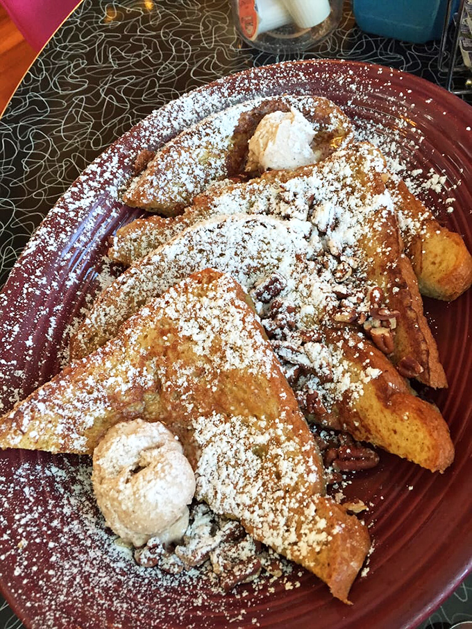 This isn't just French toast—it's a powdered sugar snowfall on a cinnamon island with whipped cream mountains. Dessert masquerading as breakfast.