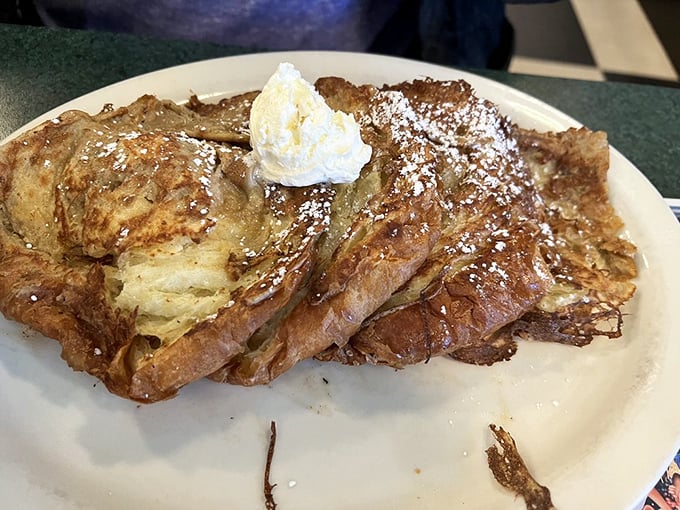 This isn't just French toast – it's croissant French toast that's living its best life with a dollop of whipped cream and powdered sugar confetti.