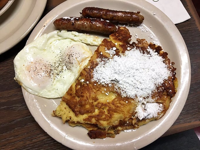 French toast dusted with powdered sugar, eggs with perfect runny yolks, and sausages with that satisfying snap—breakfast's holy trinity on one blessed plate.