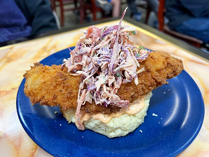 This isn't just fried chicken—it's a masterpiece of crunch atop a cloud-like biscuit, crowned with homemade slaw. Your diet doesn't stand a chance.