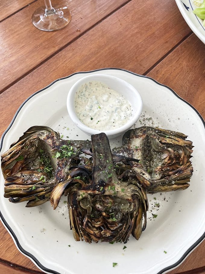 Grilled artichokes—nature's edible puzzle—transformed by fire and served with a dipping sauce worth bottling and taking home.