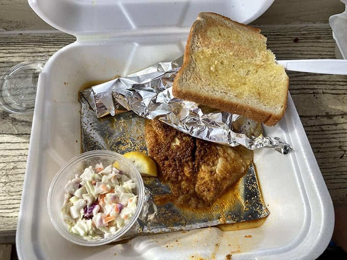 Tilapia gets the royal treatment – perfectly seasoned, served with garlic toast and coleslaw in a humble foam container fit for seafood royalty.