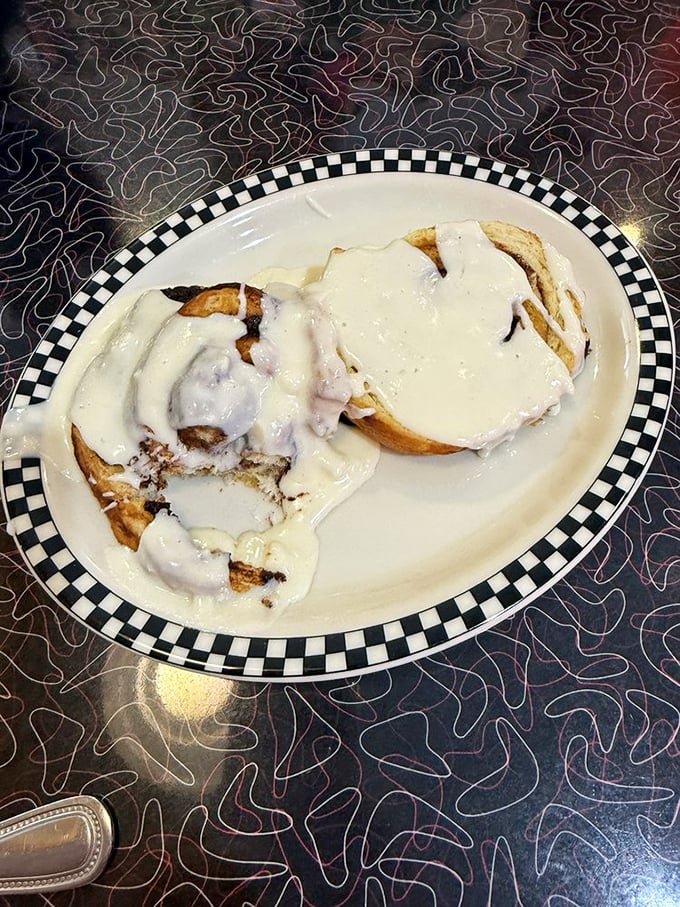 These cinnamon rolls aren't just breakfast—they're dessert masquerading as morning fuel, swimming in cream cheese icing that would make a pastry chef weep.