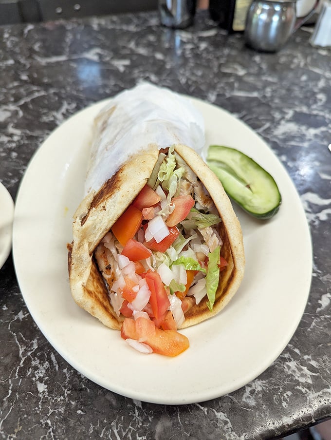 The humble gyro—Greece's gift to American diners—bursting with fresh veggies and savory meat in a warm pita embrace.