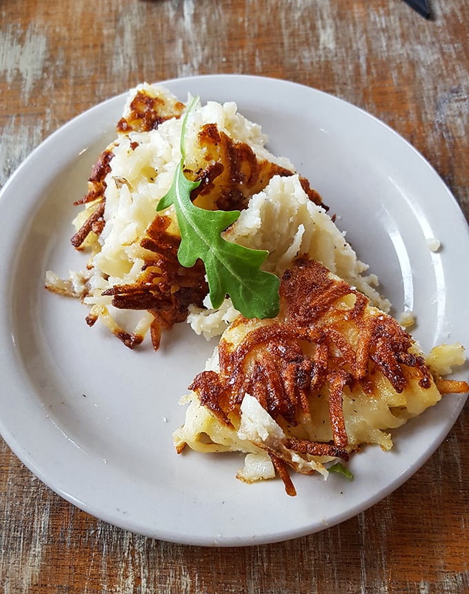 These aren't your average hash browns—they're crispy potato revelations garnished with a single arugula leaf, nature's way of saying "this is fancy."