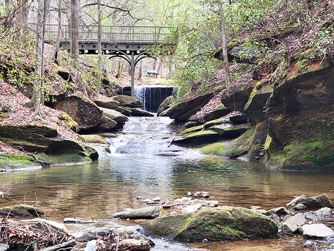 Henderson Falls Park delivers tranquility on tap—a peaceful stream cascading over ancient rocks beneath a rustic bridge. Stress doesn't stand a chance here.