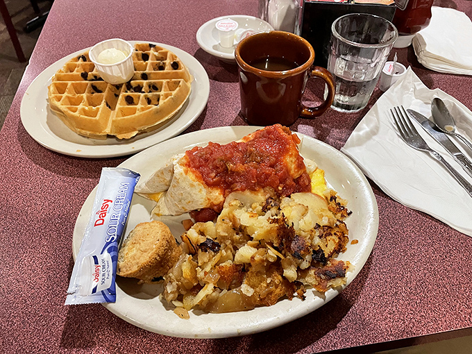 A breakfast spread that hits all the comfort food notes—homefries with perfect crispy edges, eggs, and a waffle that's clearly living its best life.