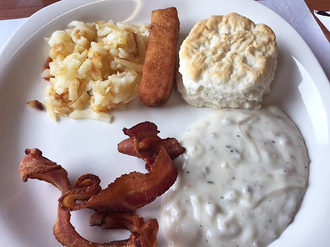 This isn't just breakfast—it's edible architecture. Crispy hash browns, flaky biscuit, thick-cut bacon, and gravy that could solve most of life's problems.