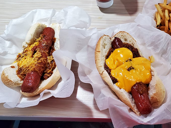 Hot dogs elevated to art form – one classic with chili and cheese, one boldly dressed with mustard. Comfort food that speaks a universal language.