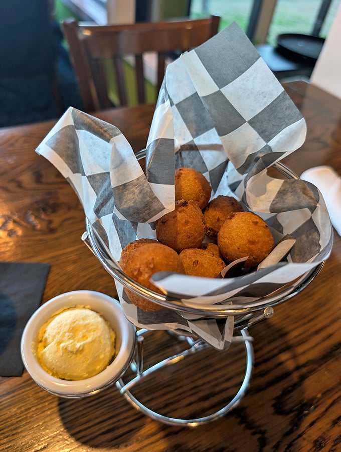 Hush puppies that actually make you want to speak up—golden-fried perfection with a hint of sweetness, served with butter that melts just looking at these hot little spheres of joy.