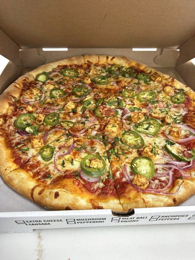 This pizza isn't just food—it's art. Jalapeños and red onions create a colorful masterpiece atop that perfectly baked crust.