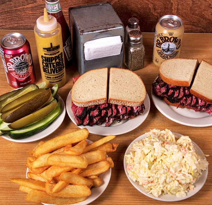 A proper deli spread that would make your grandmother nod in approval—towering sandwiches, crisp pickles, golden fries, and coleslaw that doesn't know the meaning of "afterthought."