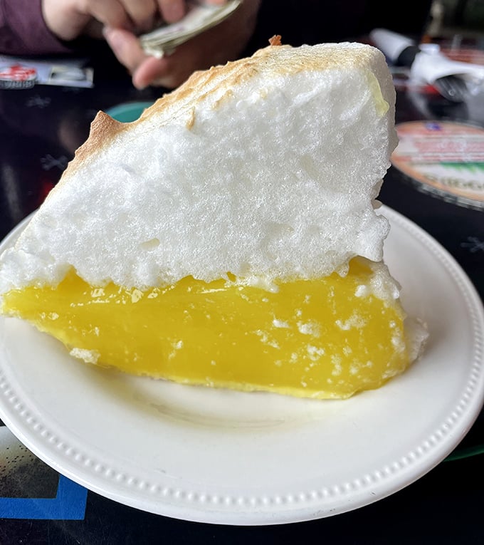 Lemon meringue pie that defies gravity—cloud-like meringue floating above sunshine-yellow filling. This isn't dessert; it's edible optimism on a plate.