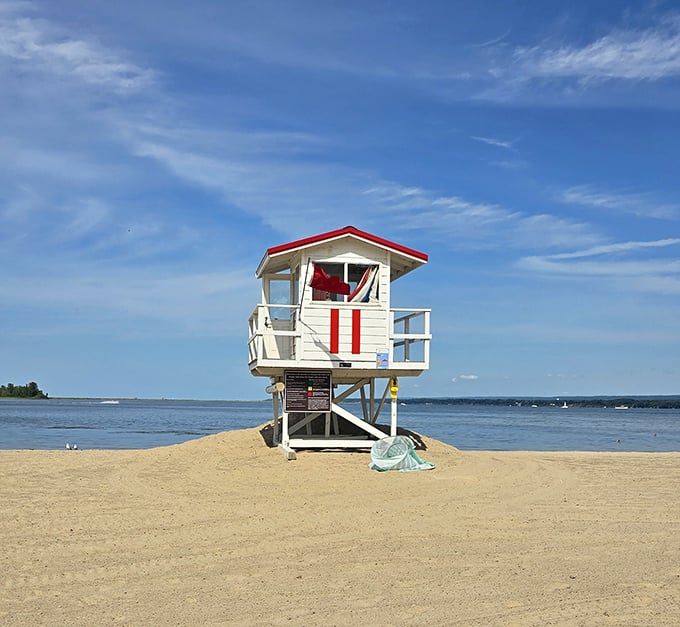 This classic red-roofed lifeguard station stands ready for action, like a beachside superhero headquarters monitoring Lake Erie's gentle waves.