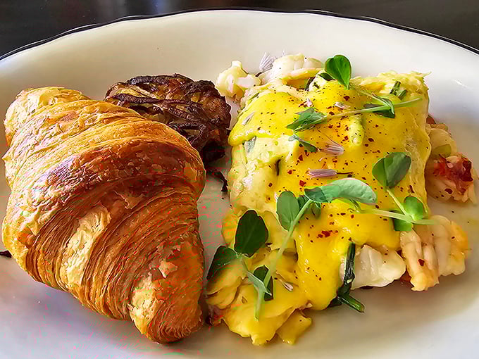 Brunch reaches new heights with this golden croissant alongside eggs that have clearly been on better terms with butter than my cardiologist would approve.