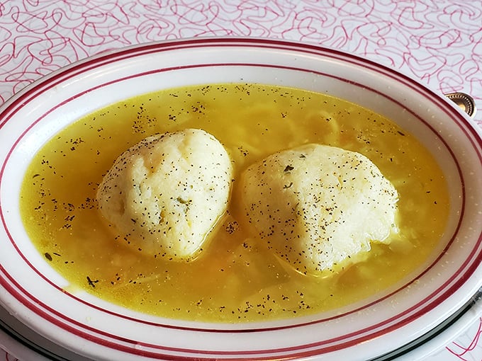 The famous matzo ball soup—where fluffy dumplings float like edible clouds in a golden broth that grandmothers everywhere would approve of.