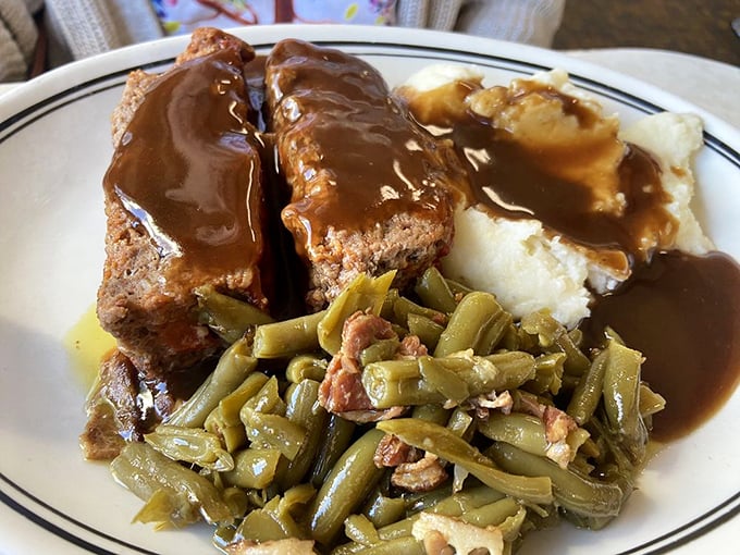 Meatloaf that would make your grandmother nod in approval, swimming in rich gravy alongside perfectly seasoned green beans and cloud-like mashed potatoes.
