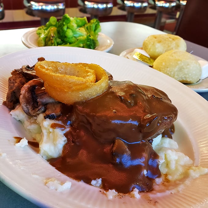 This isn't just meatloaf—it's a gravity-defying masterpiece of comfort, swimming in gravy atop a cloud of mashed potatoes. Grandma would approve.