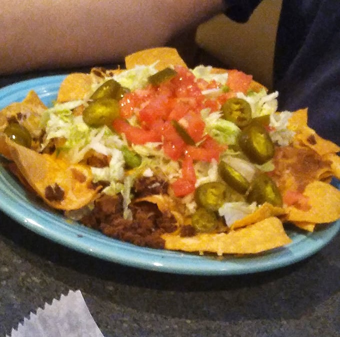 These nachos aren't just a snack; they're a topographical masterpiece of cheese, jalapeños, and happiness that demands to be explored.